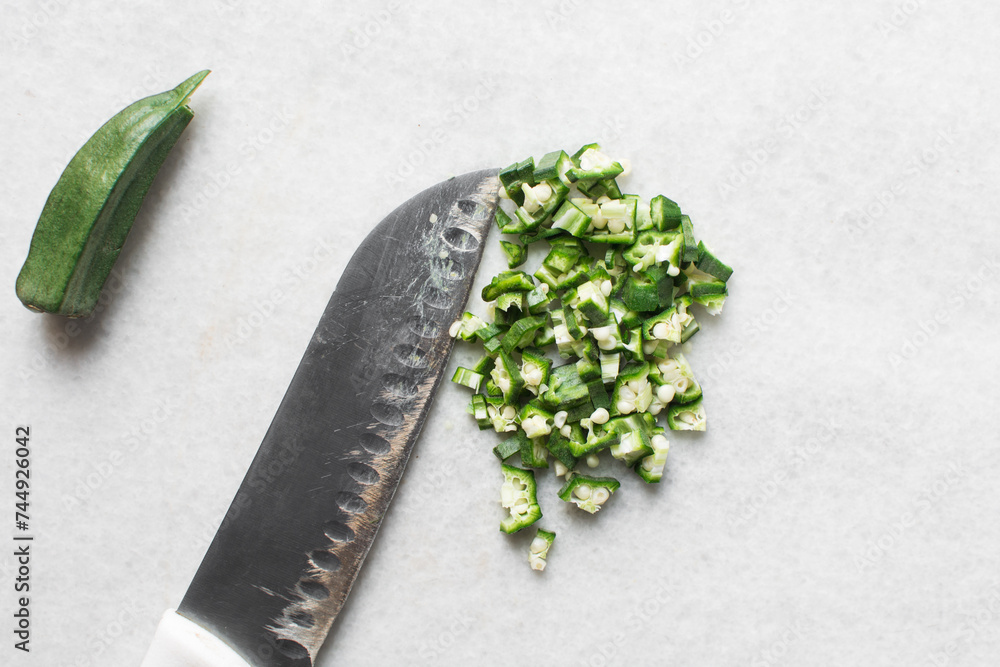 Top view of chopped okra on a white chopping board, lady fingers on a ...