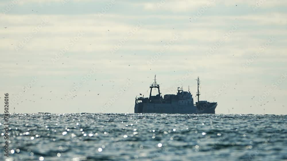 Fishing boat trawler catches fish while sailing on sea. A commercial ...