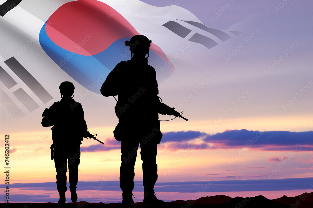 Silhouettes of a soldiers with South Korea flag against the sunset ...