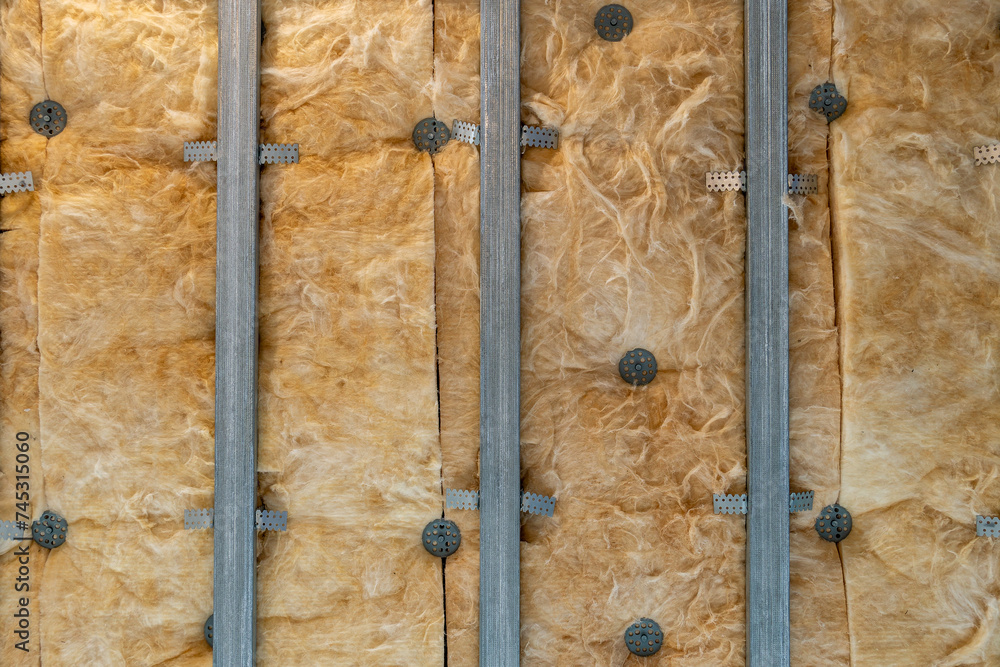 Metal ceiling framework with soundproofing, fixed to concrete using ...