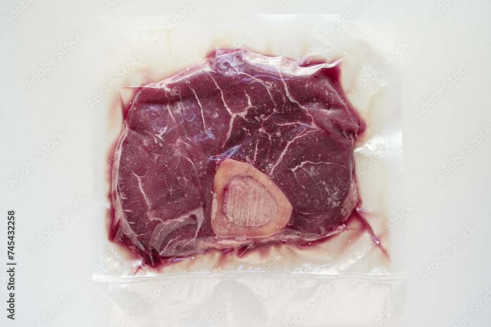Organic beef (osso buco) in vacuum sealed package with white background ...
