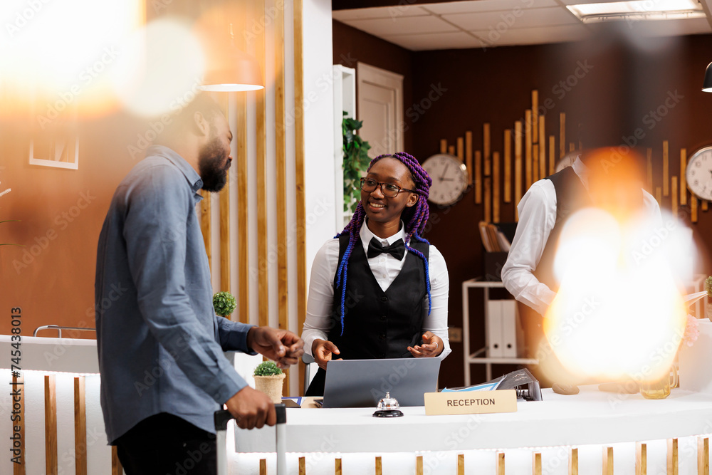 Smiling friendly African American woman receptionist talking with man ...