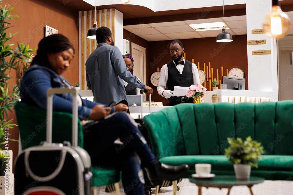 Hotel front office team welcoming and registering guest at reception ...