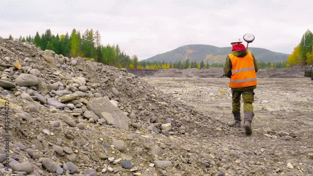 Surveyor With Prism Pole Tool Passing By Excavated Stones At Gold Mine ...