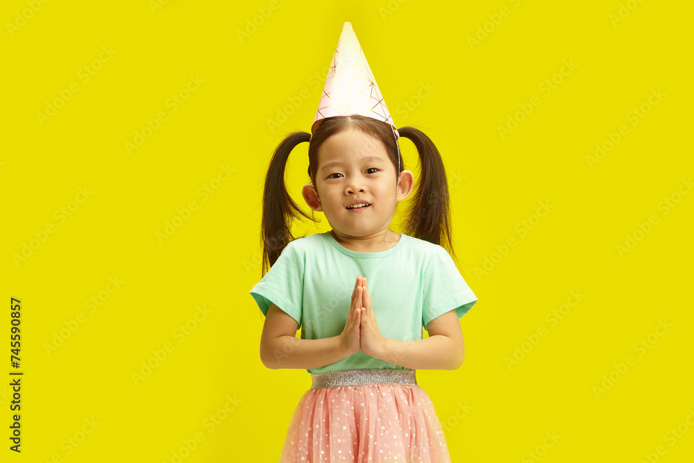Grateful Child Girl with Party Hat Clasped hands in front of her ...