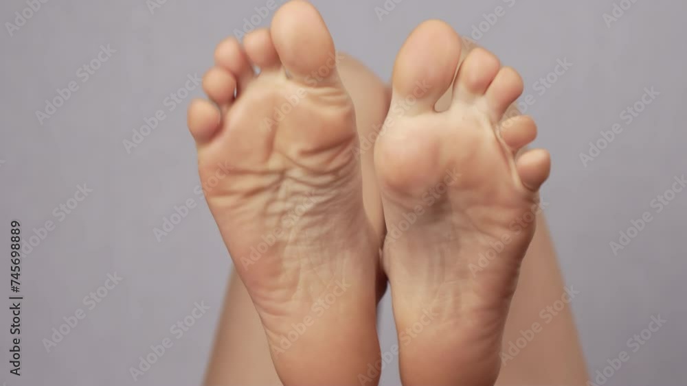 Close up woman wiggles fingers toes while lying on bed in room. Female ...