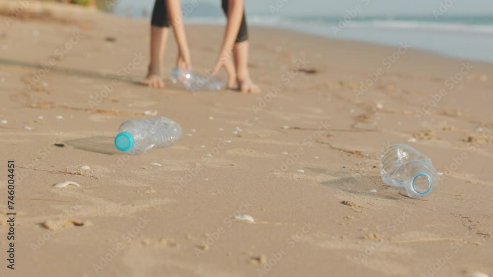 Close up of abandoned PET plastic bottle on the sand and kid picking it ...