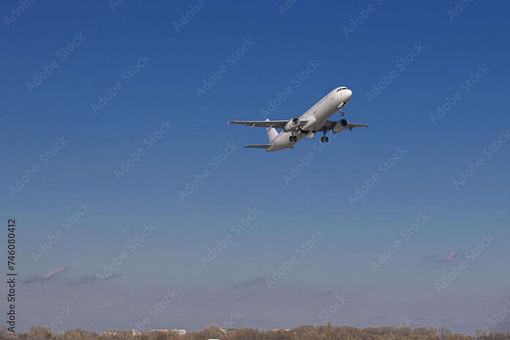 Airplane taking off from the airport. White Passenger plane fly up over ...