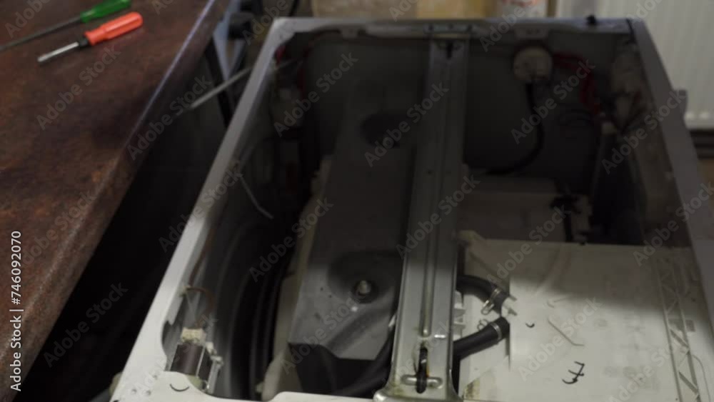 open the lid of the washing machine, a craftsman repairs a washing ...