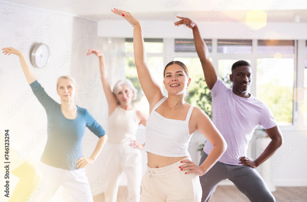Young girl coach oversees mentoring group of elderly clients in fitness ...