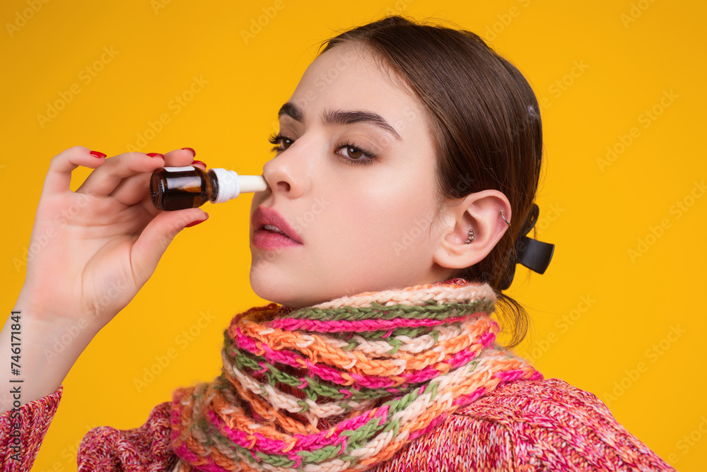 The nasal spray. Female in scarf using nasal spray medicine for runny ...