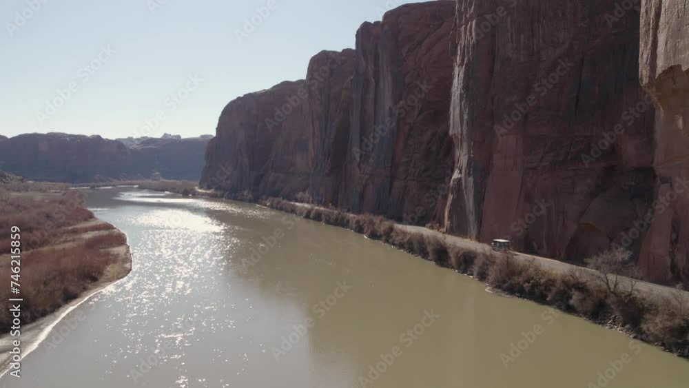 A tracking drone shot of a truck driving between the steep cliffs ...