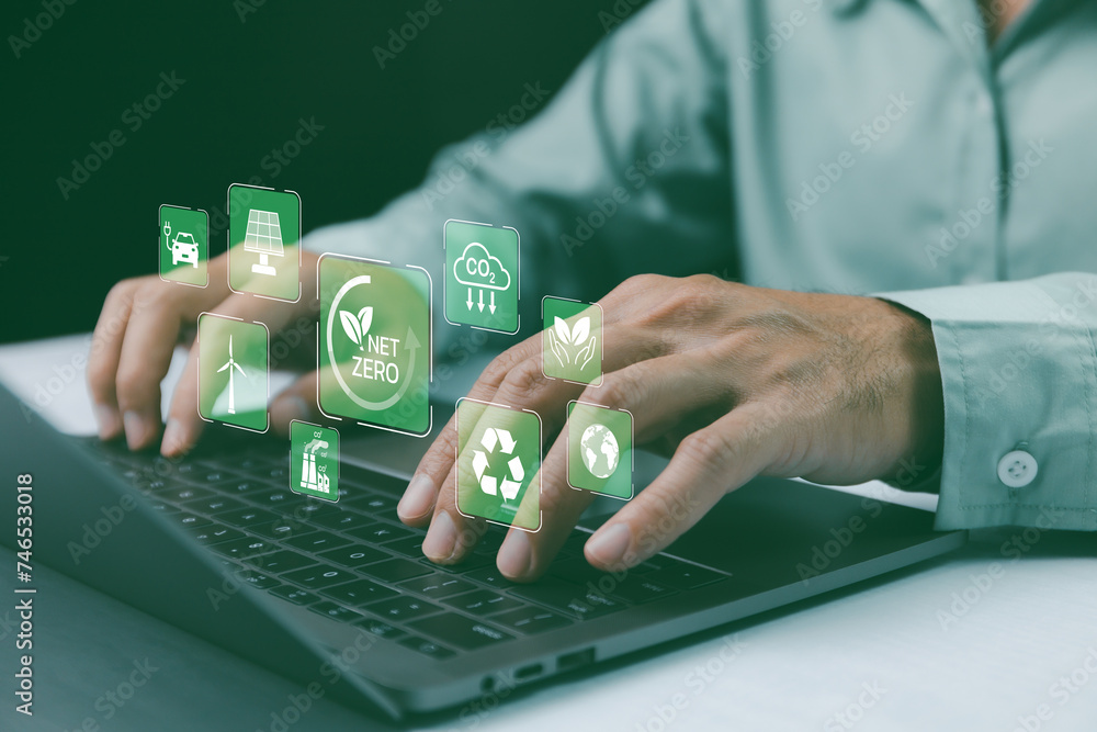 Net-zero and carbon-neutral concept. Person use laptop showcasing eco-friendly icons including ...