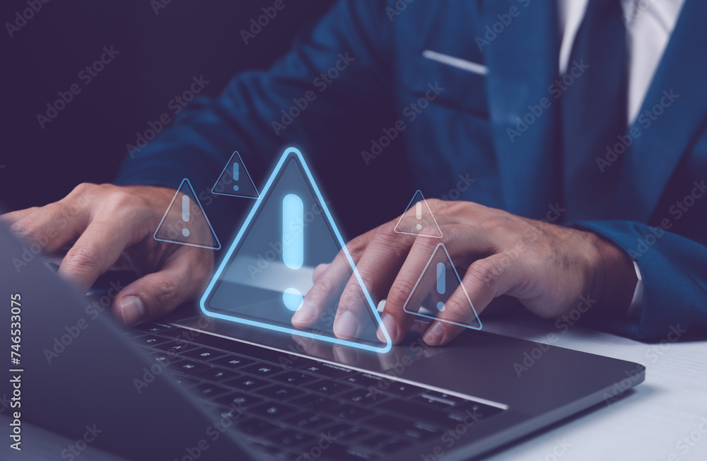 Man use laptop, digital alert symbols hover over keys, concept of cyber security and data ...