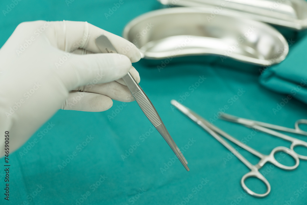 Surgeon doctor's hand with hygiene glove taking forceps surgical set ...