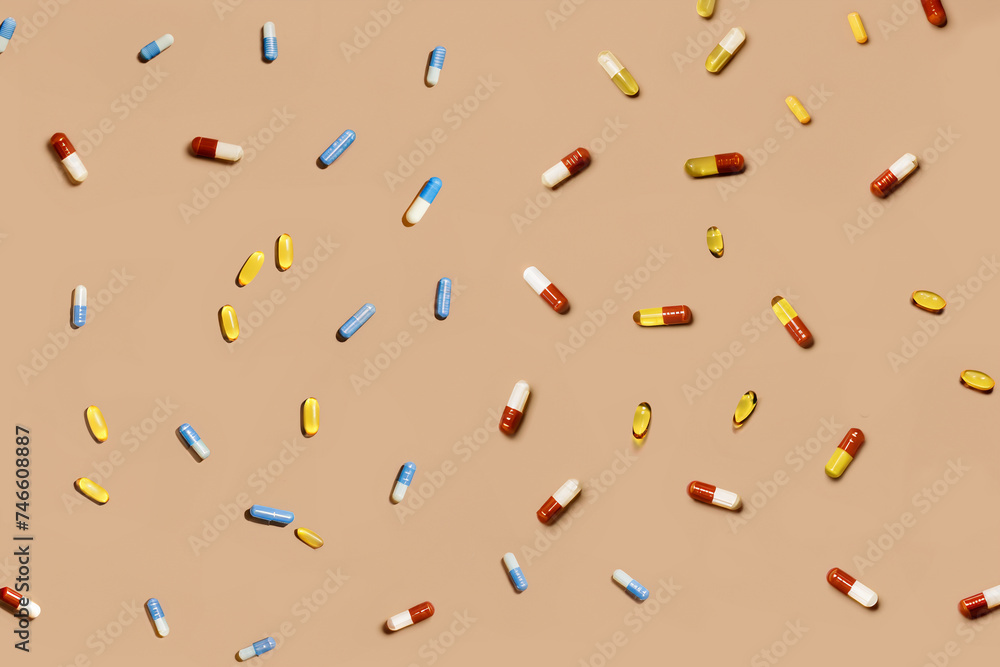 Variety of different pills capsules arranged on peach background ...
