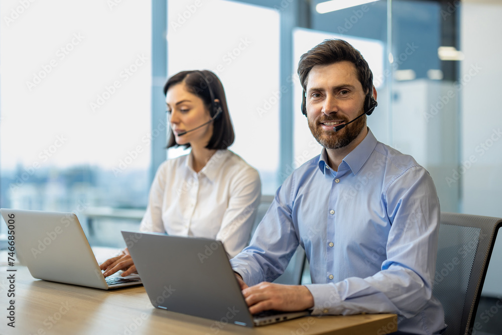Couple of customer support managers in headsets with microphones ...