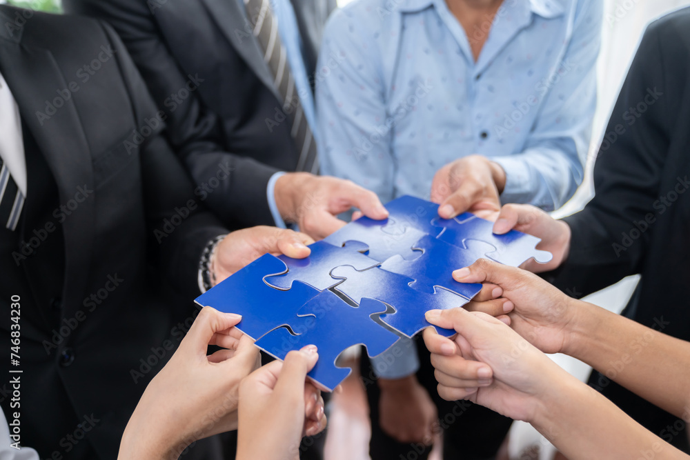Multiethnic business people holding jigsaw pieces and merge them ...