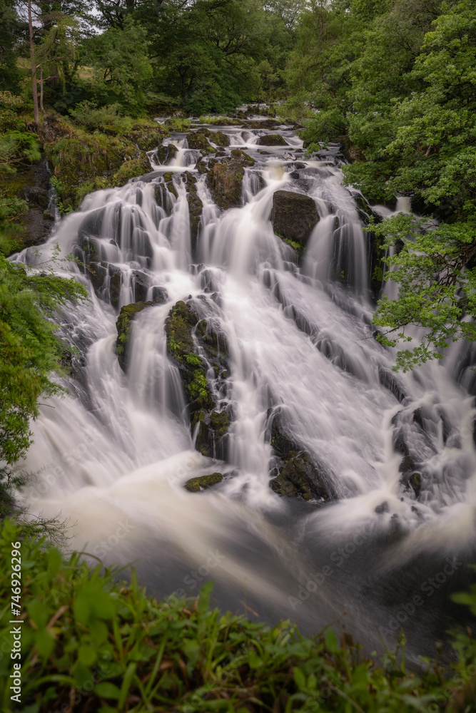 Beautiful cascading waterfall through a lush green landscape - Rhaeadr ...