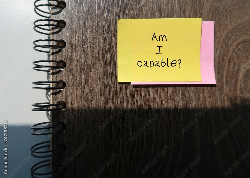 Notebook on shadow with handwritten note AM I CAPABLE? SELF-DOUBT ...