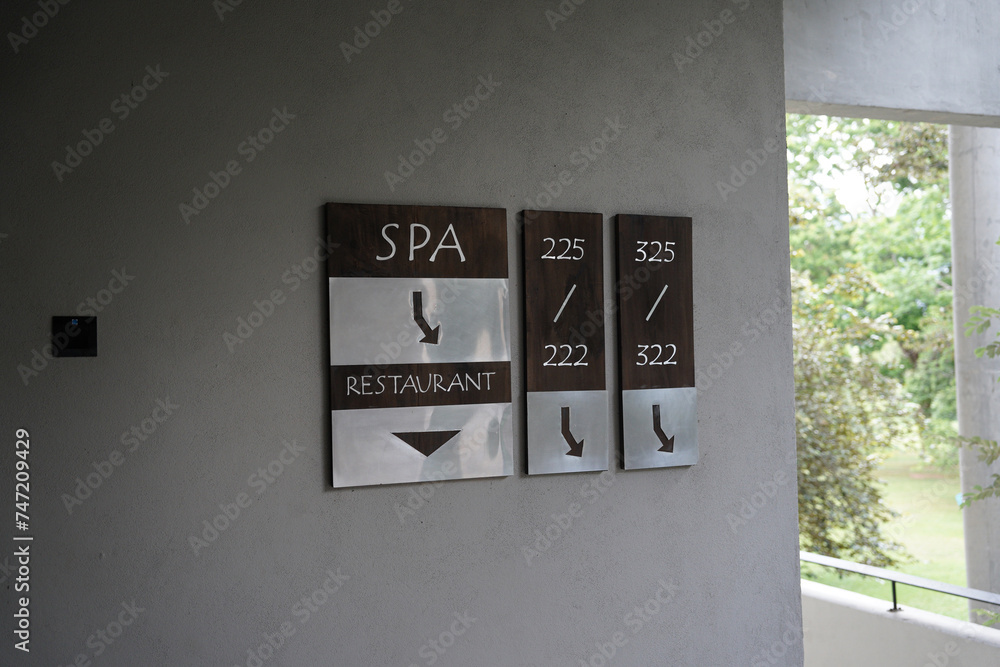 spa and restaurant wooden and steel signs on a wall with room numbers ...