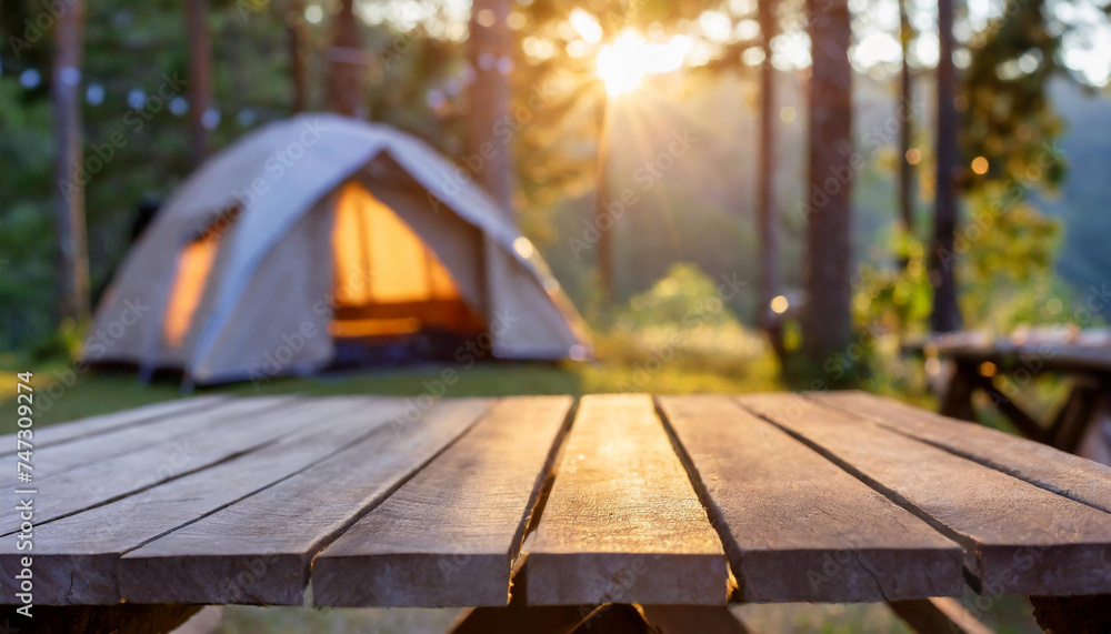 Wooden table in the blur camping tent at sunset in the mountain. Cool ...