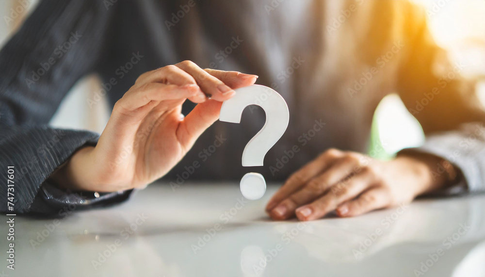 hand holding 3D question mark on white table, symbolizing curiosity and ...