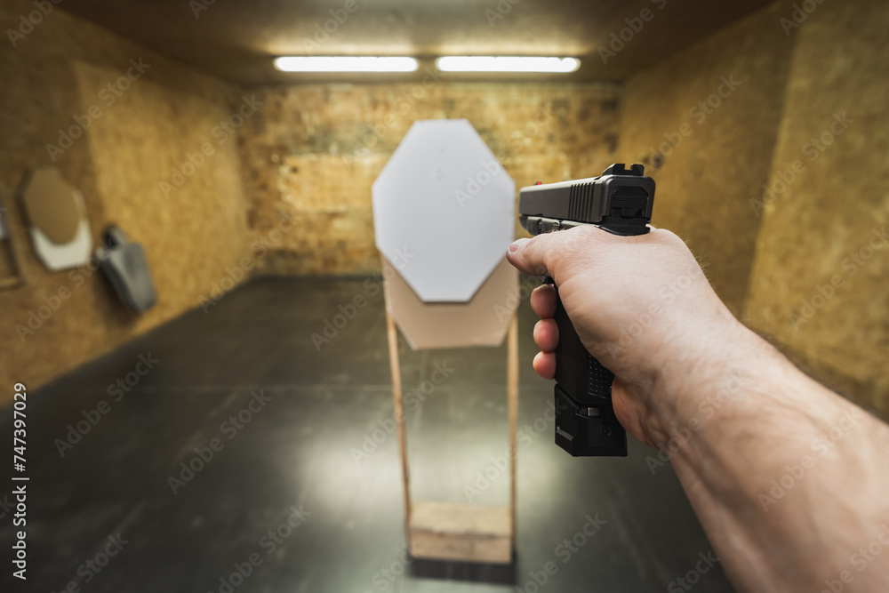 Fotografia do Stock: Shooting a pistol with one hand at a shooting ...