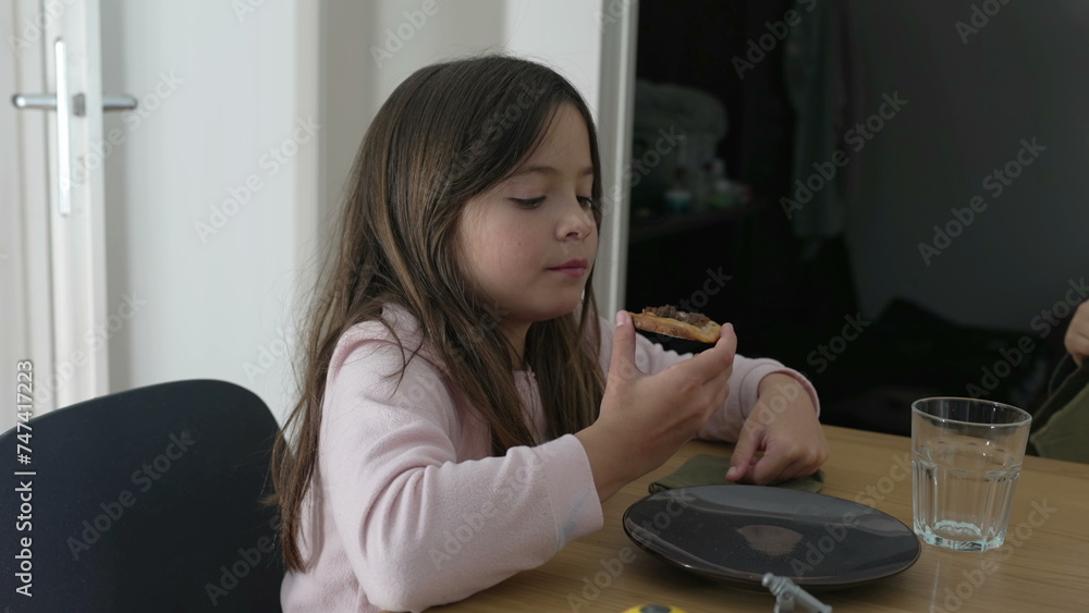 One little girl eating during mealtime interacting with family off ...