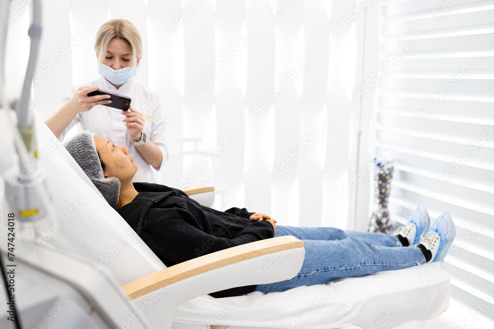 A doctor cosmetologist takes photographs of the facial proportions of a ...