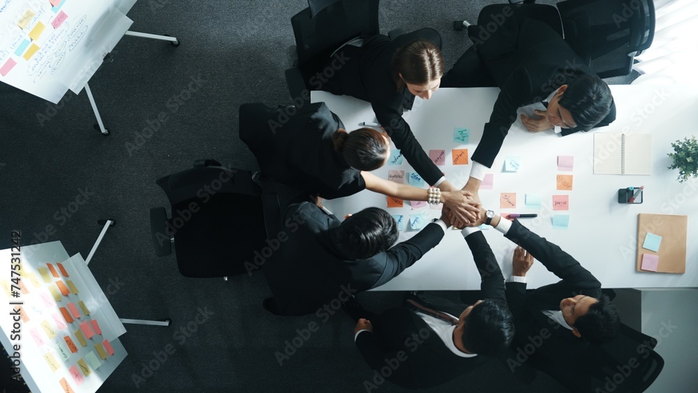Top down aerial view of professional investor team putting hand ...