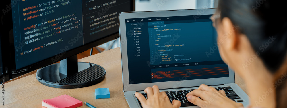 Cropped image of female web developer coding on laptop while computer ...