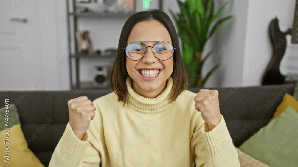 At home, a young and beautiful hispanic woman ecstatically screaming in ...