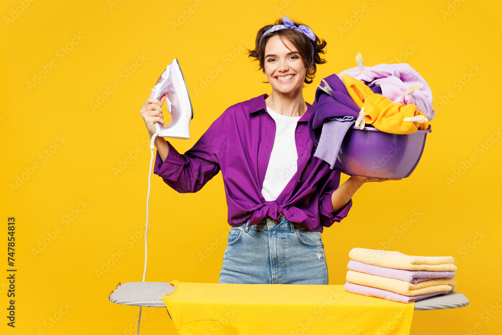 Young smiling woman she wear purple casual shirt do housework tidy up ...