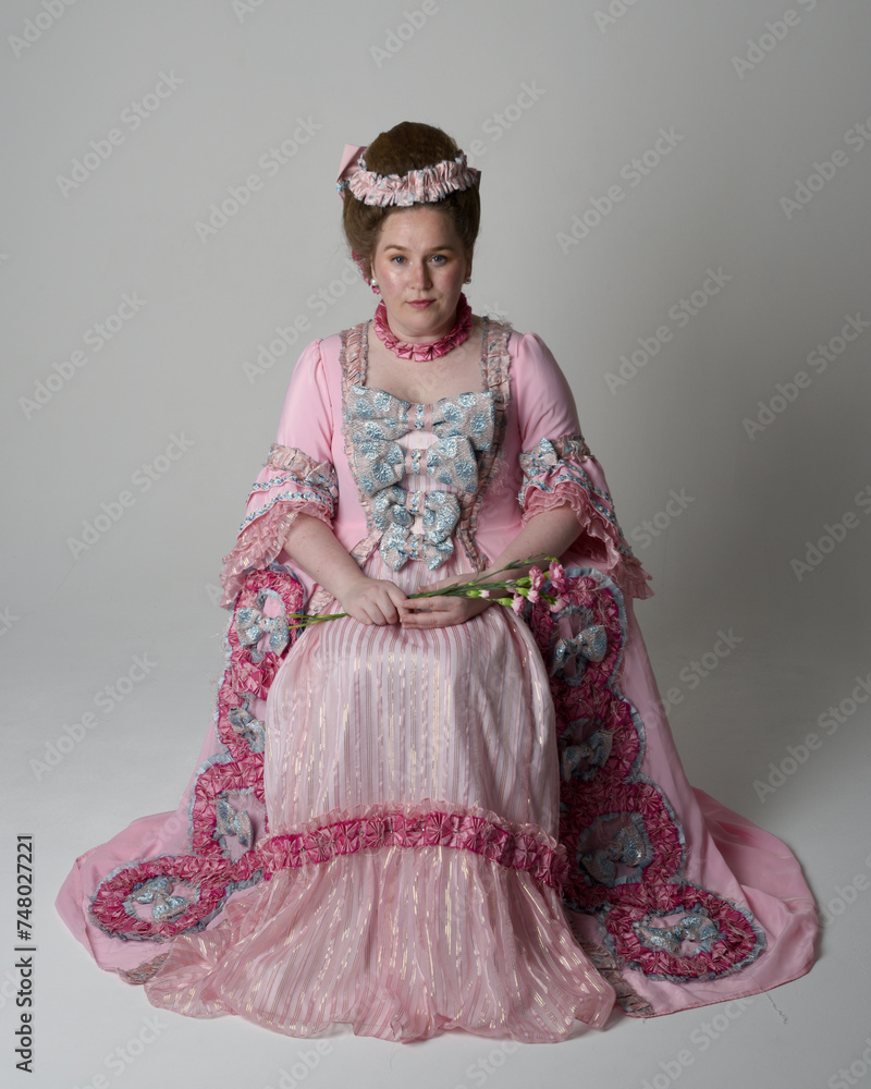 Fun length portrait of female model wearing an opulent pink gown ...