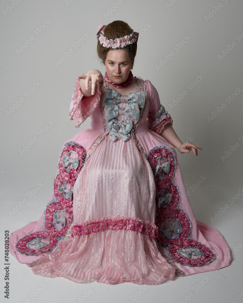 Fun length portrait of female model wearing an opulent pink gown ...