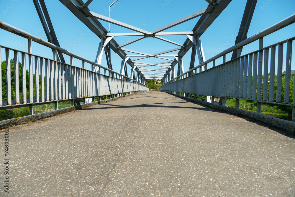 Parts of a modern metal bridge in close-up against a blue sky ...