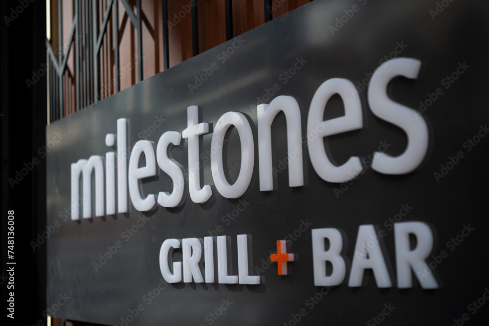 shallow depth of field focus on an exterior sign of Milestones, a ...