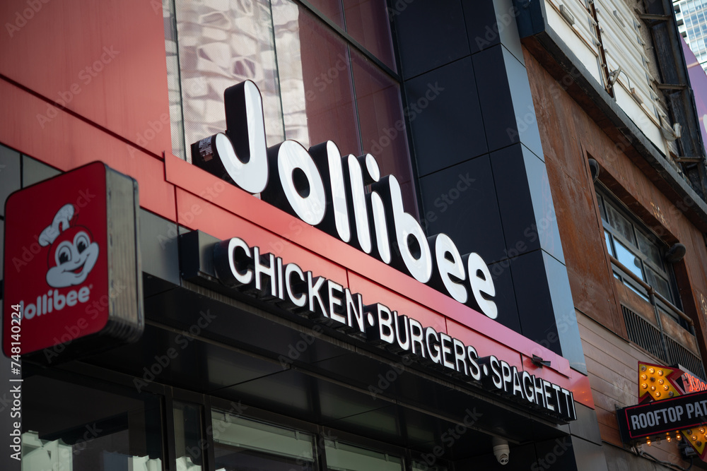 exterior building facade and sign of Jollibee, a chicken restaurant ...