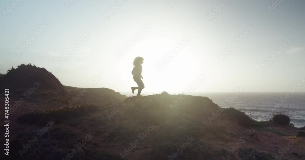 Cinematic shot of silhouette of unrecognisable woman run up to the top ...