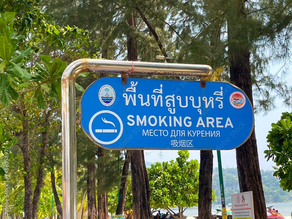 Sign, closeup view, indicating the smoking area on Thai beaches. White ...