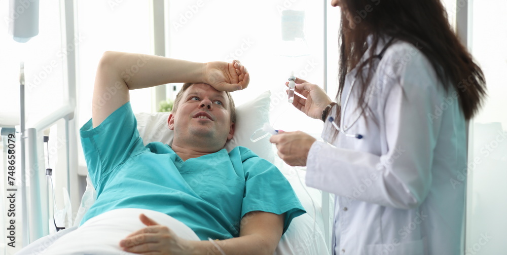Female doctor preparing dropper for male patient. Observation patients ...