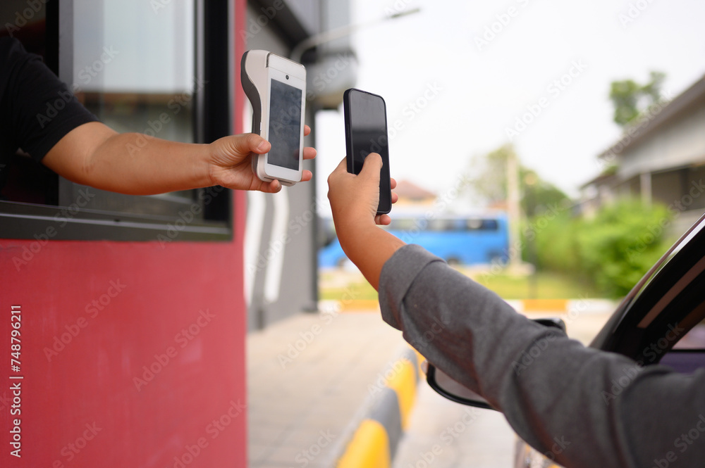 Men scan and pay for food, pick up food from a drive-thru counter and ...