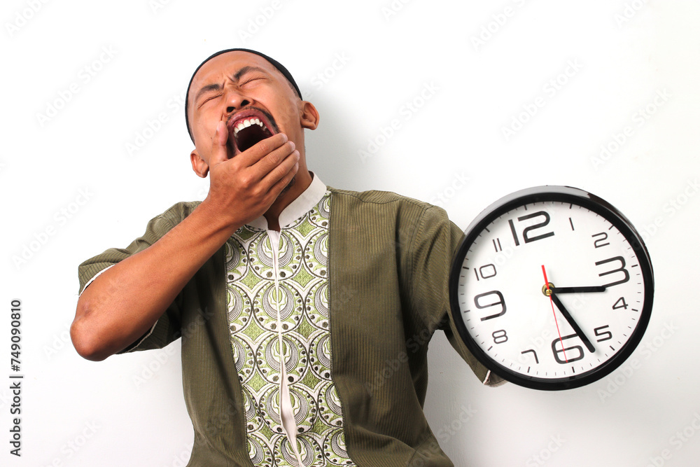Sleepy Indonesian Muslim man in koko and peci stifles a yawn while ...