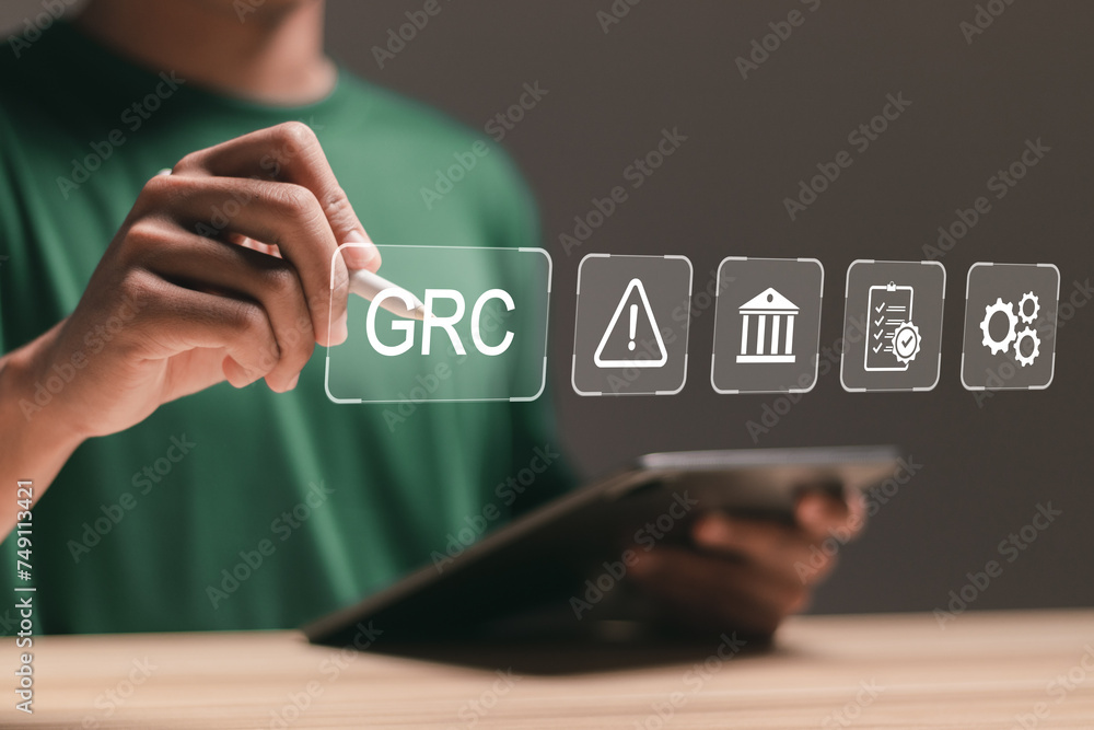 GRC, Governance Risk and Compliance concept. Person using tablet with ...