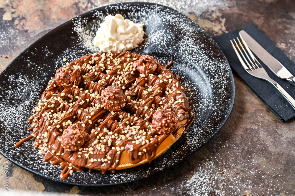 Ferrero Rocher Waffle with chocolate, whipped cream, knife and fork ...
