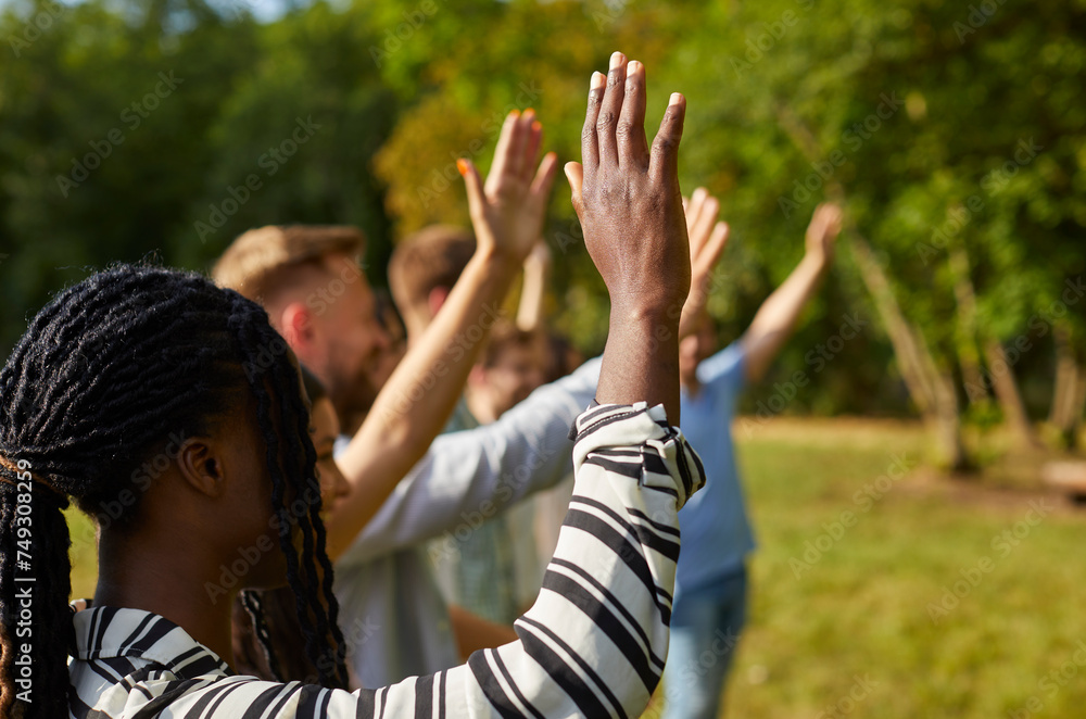 Diverse audience raising hands up to ask questions at outdoor ...