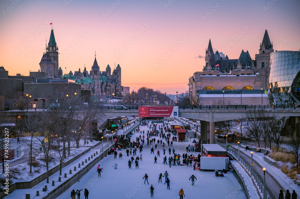 Downtown Ottawa during winter with skaters on the Rideau Canal Skateway ...