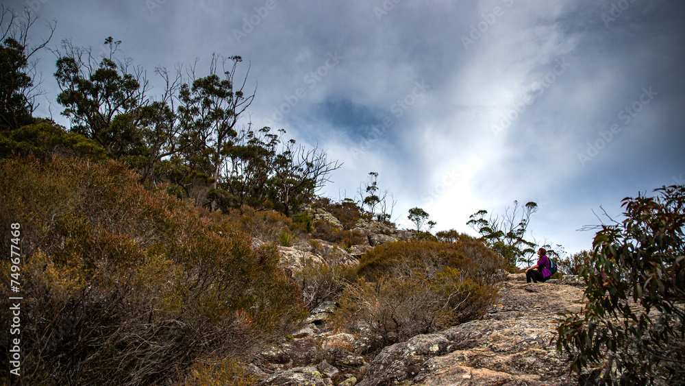 brave fit girl climbing to the top of mount maroon; rock scrambling in ...