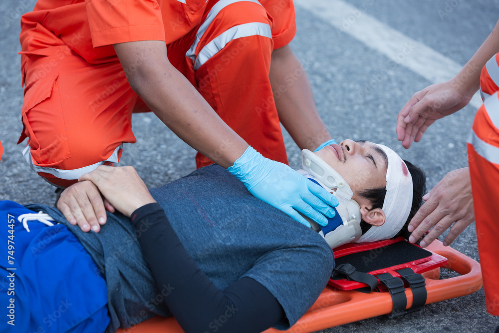 Injured man on patient transport stretcher. Ambulance staff member ...